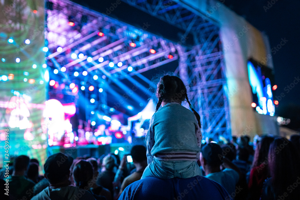 Young girl watching a concert from her dad shoulders Stock Photo ...