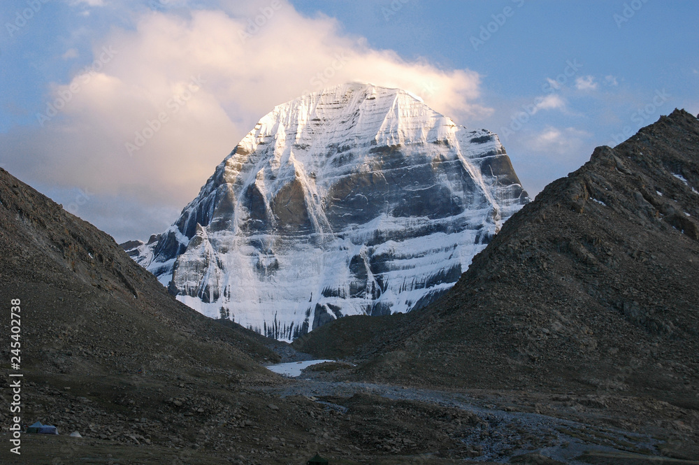 The peak of the sacred mount Kailash lit by the sun on background white ...