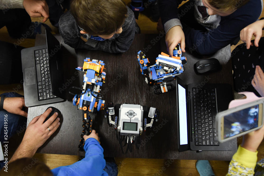Group of kids building robot constructor from the plastics details ...