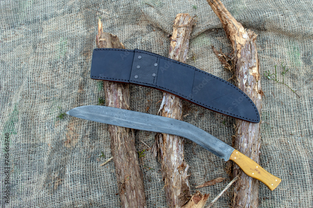 An extra large traditional style Kukri knife and leather sheath on top ...