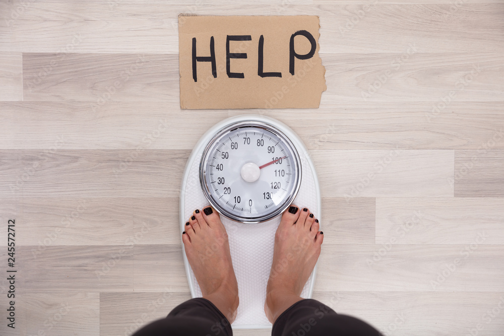 Help Sign With Woman's Feet On Weighing Scale Stock Photo | Adobe Stock