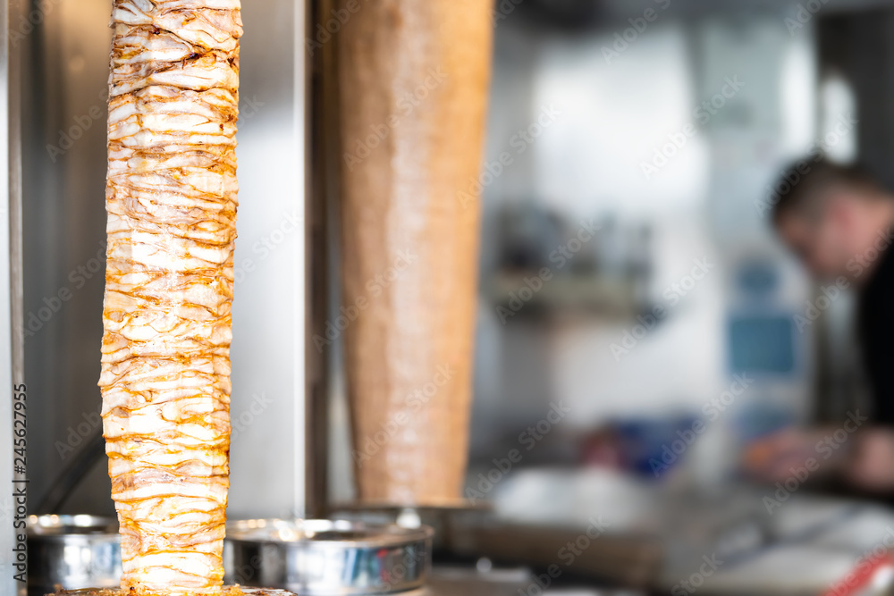 Meat carving grilled kebab closeup with chef in background in building ...