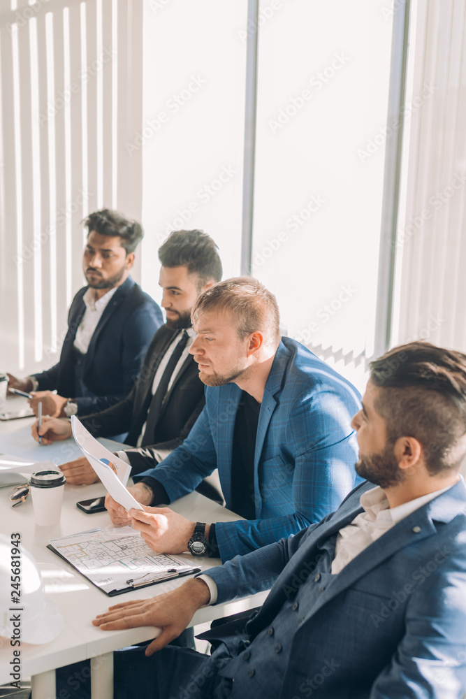 Diverse business executives discussing project sitting at conference ...