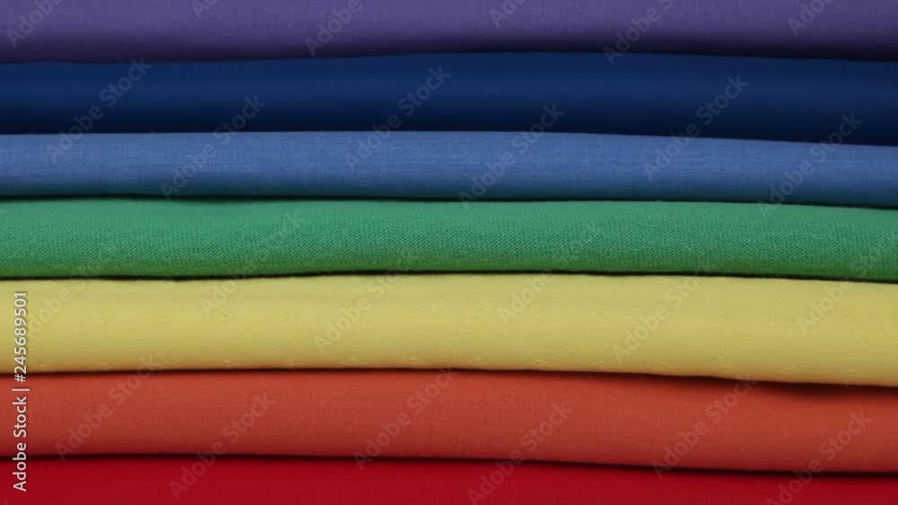 Colorful cotton fabrics are stacked in the spectrum of the colors of ...