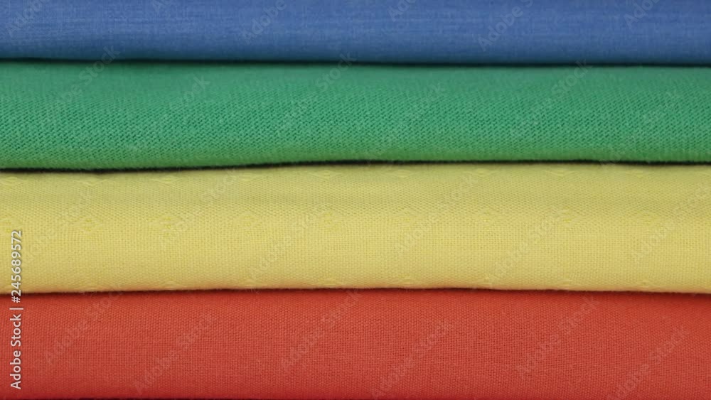 Colorful cotton fabrics are stacked in the spectrum of the colors of ...