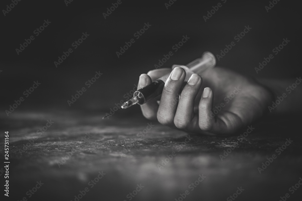 Woman hand of a drug addict and a syringe with narcotic syringe lying ...