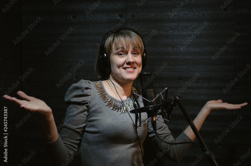 Confused woman a singer in a headphones is guiltily spreading hands in ...