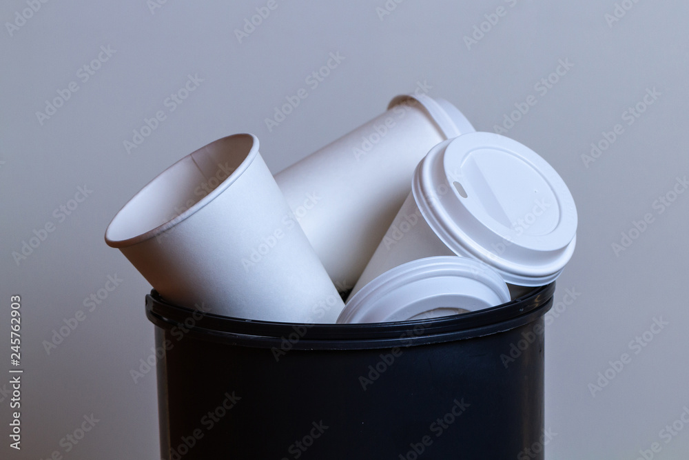 Garbage bin overflowing with paper, coffee cups. Coffee addiction and ...