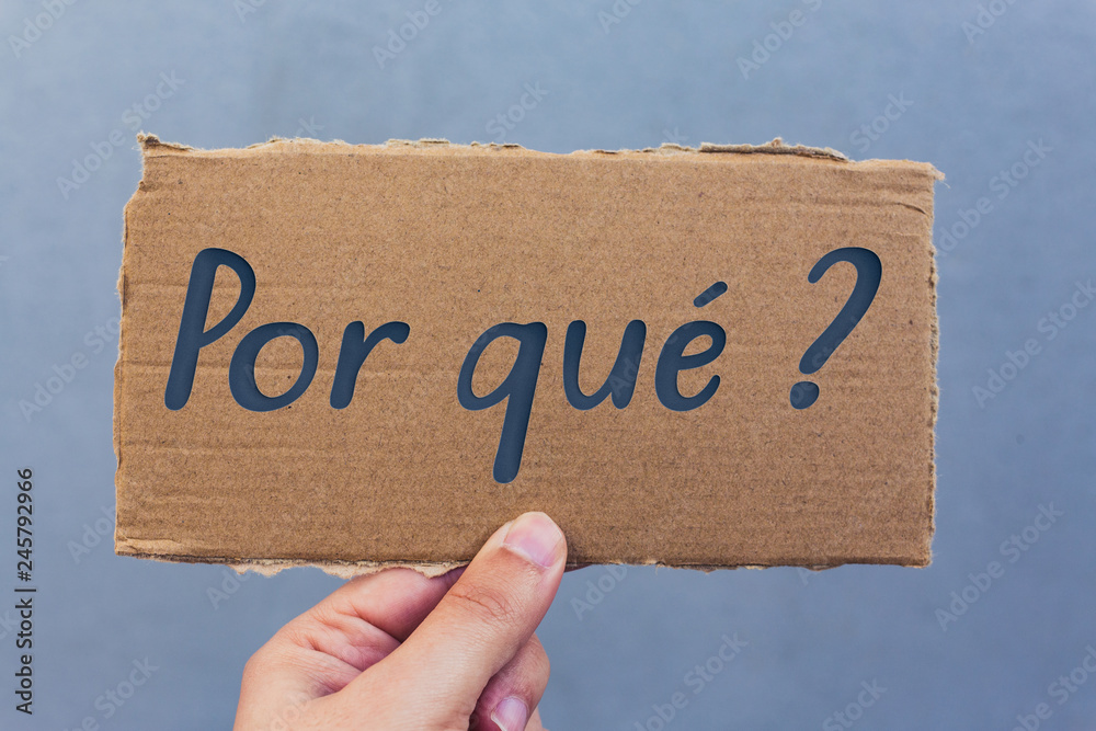 Hand holding on a cardboard with the word Por qué ( why in english ...
