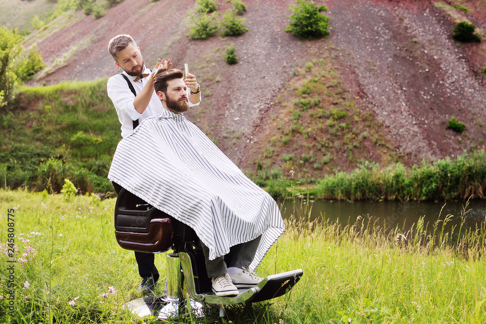 Barber does her hair and shaves the beard of the client in the Barber ...