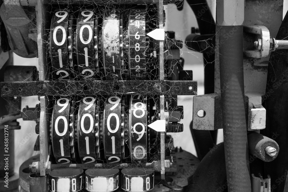 The internal workings of an old gas pump are covered with a fine spider ...