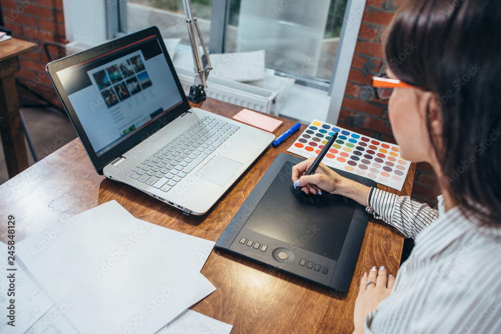 Close-up image of women drawing a project using a graphic tablet and a ...