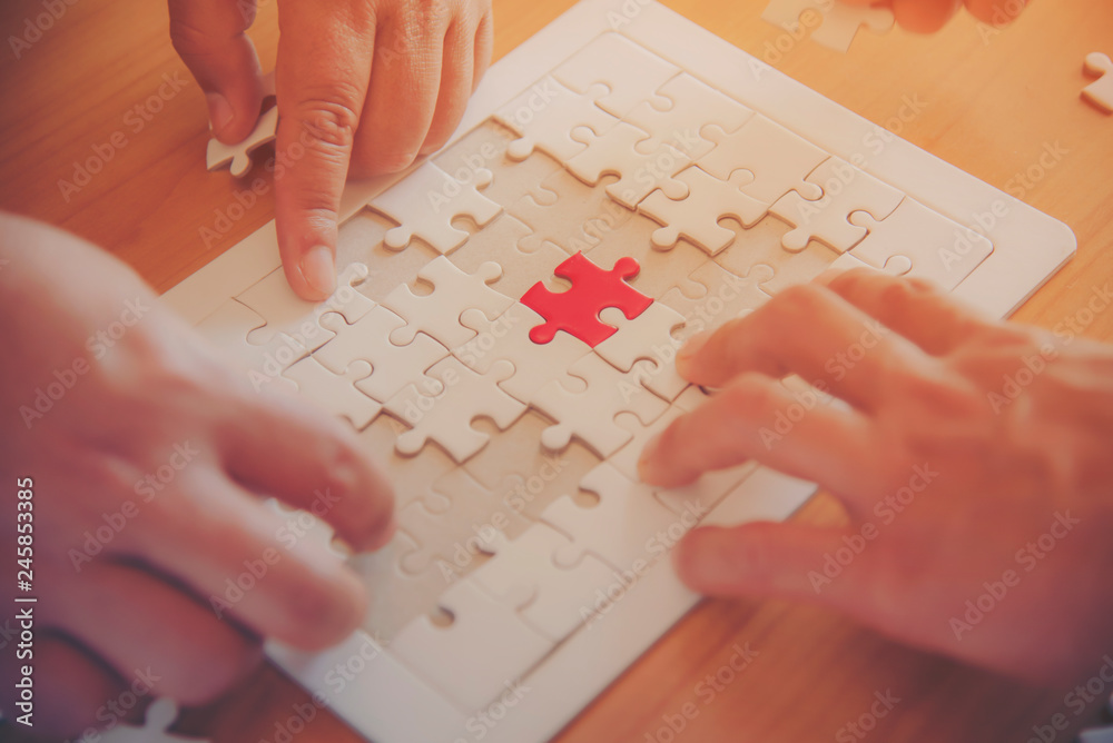 Hands of diverse people assembling jigsaw puzzle, team put pieces ...