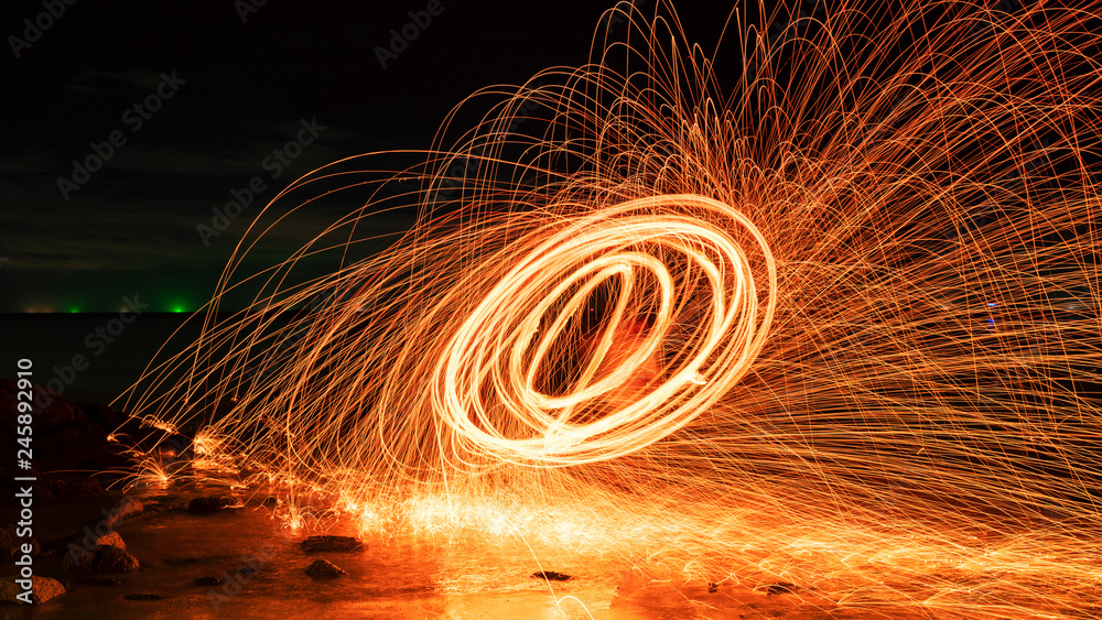 Swing fire Swirl steel wool light photography over the stone with ...