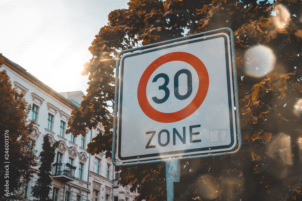 30 speed sign in a city street with sun flare Stock Photo | Adobe Stock