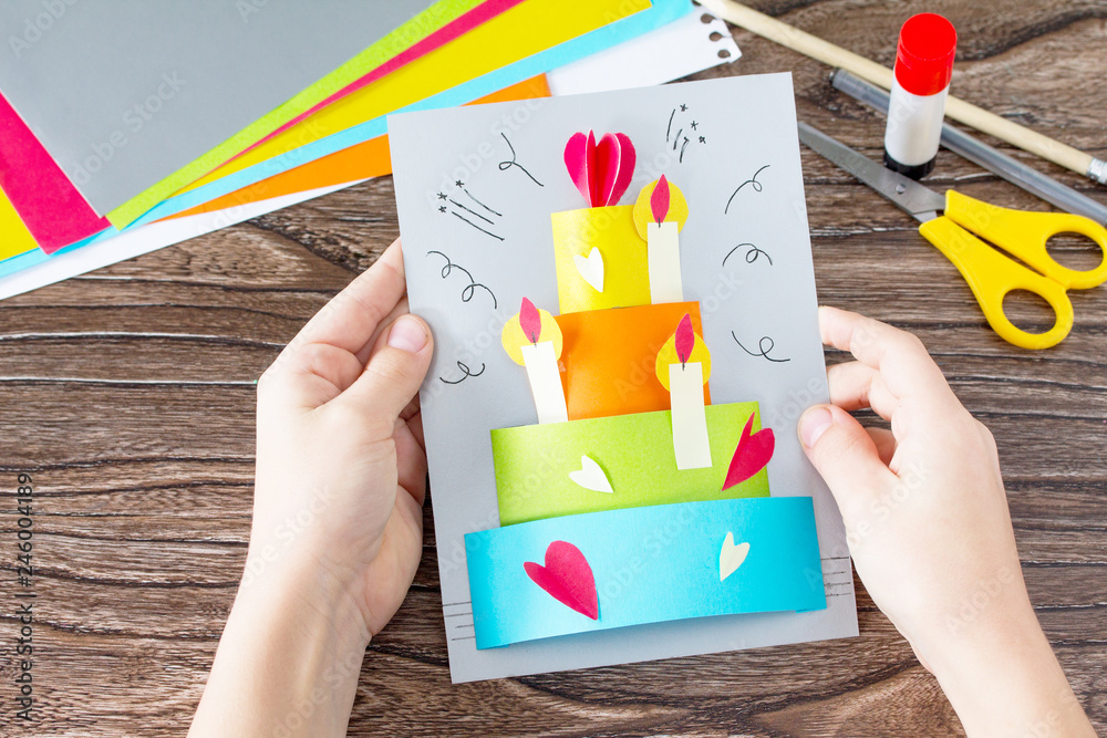 The child holds Greeting card with birthday cake congratulation ...