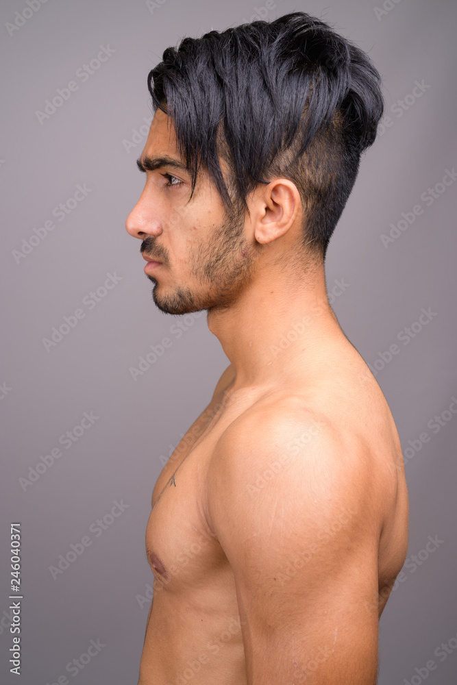 Young handsome Persian man shirtless against gray background Stock Photo | Adobe Stock