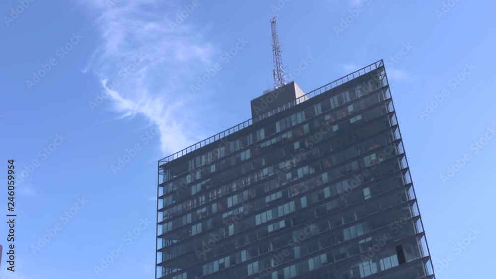 Thin white clouds blow past the top of the Kista Science Tower. Sharp ...