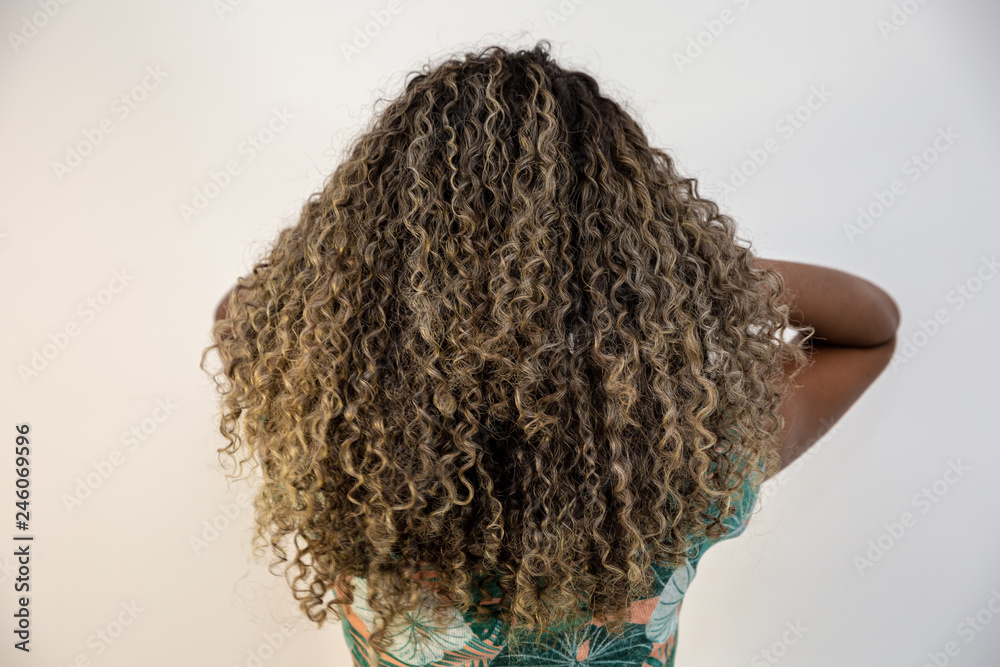 Young black woman on her back with afro hairstyle on white background ...