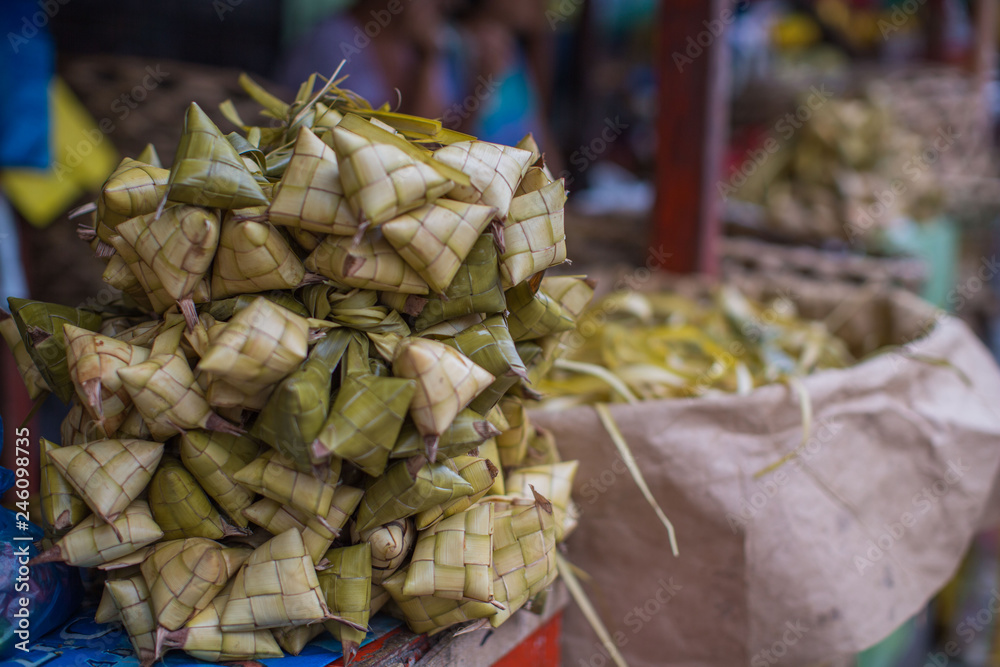 group of hanging rice, rice plaited in coconut leaves at a local street ...