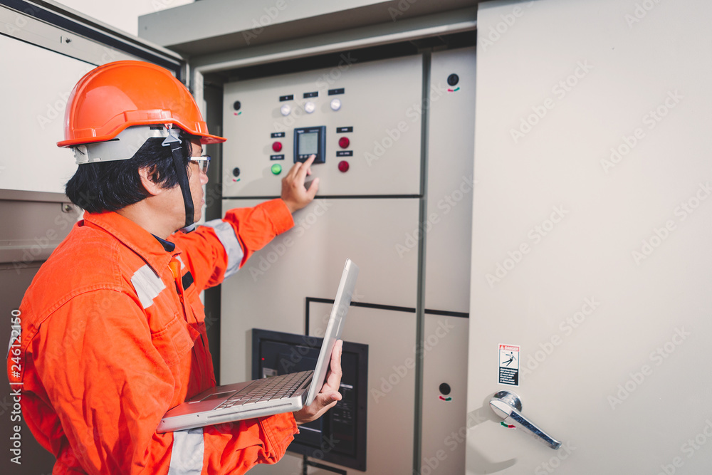 engineer or electrician holding laptop for inspect and checking main ...