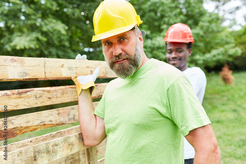 Bauarbeiter mit Schutzhelm trägt Transportpalette Stock Photo | Adobe Stock