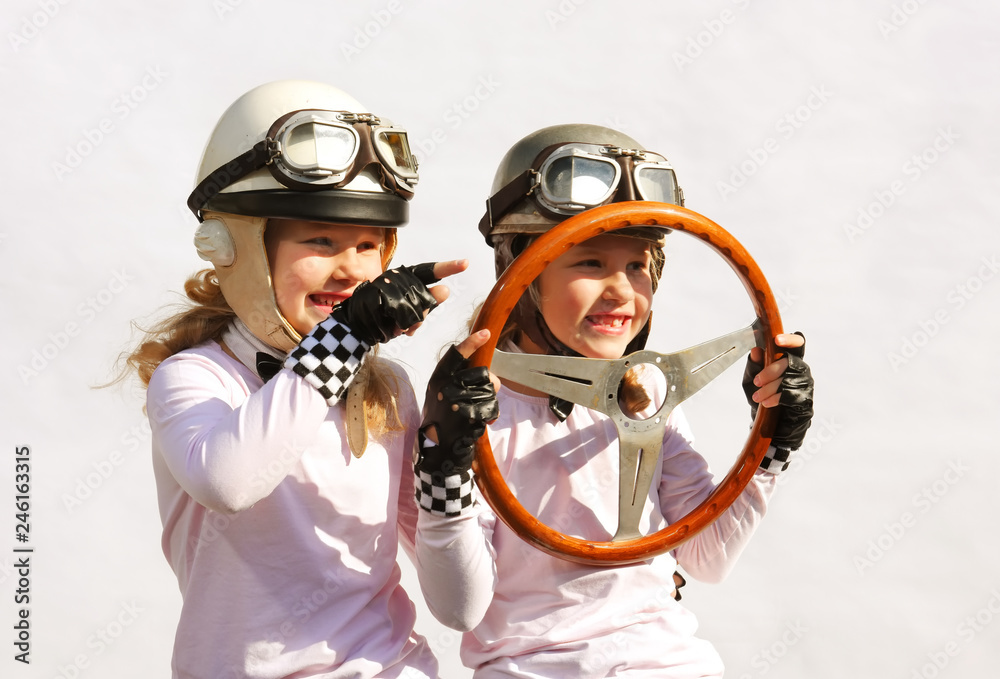 Twin sisters play race car driver sitting in their imaginative sports ...