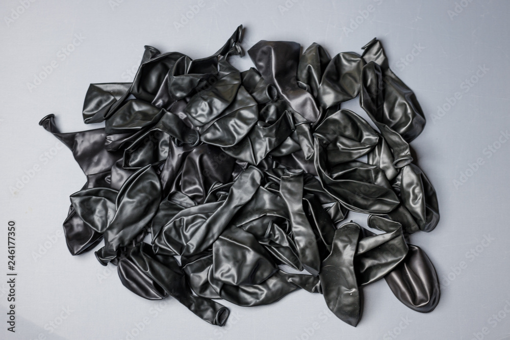 Pile of deflated black balloons on a white background. Clean pure ...
