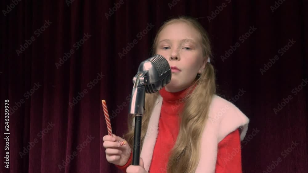 Girl singer singing song front retro microphone on dark stage while ...