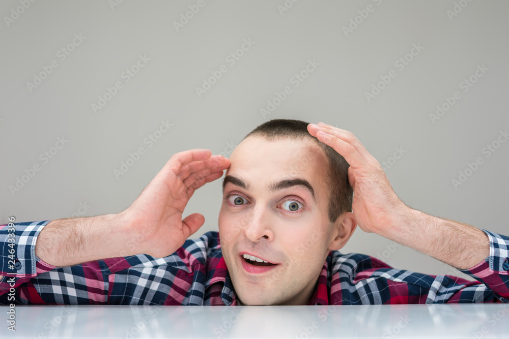 Dazed man looks at the camera in surprise, copy space, front view ...