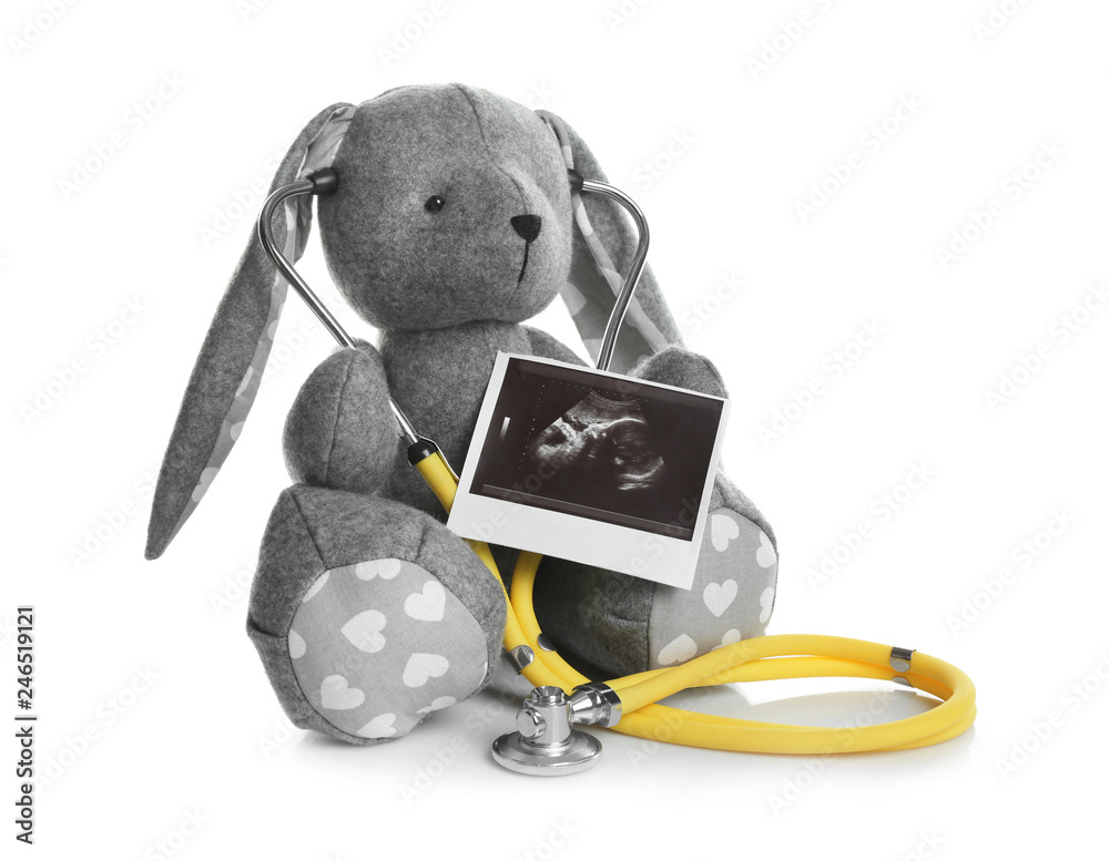 Ultrasound photo of baby and toy rabbit on white background. Concept of ...