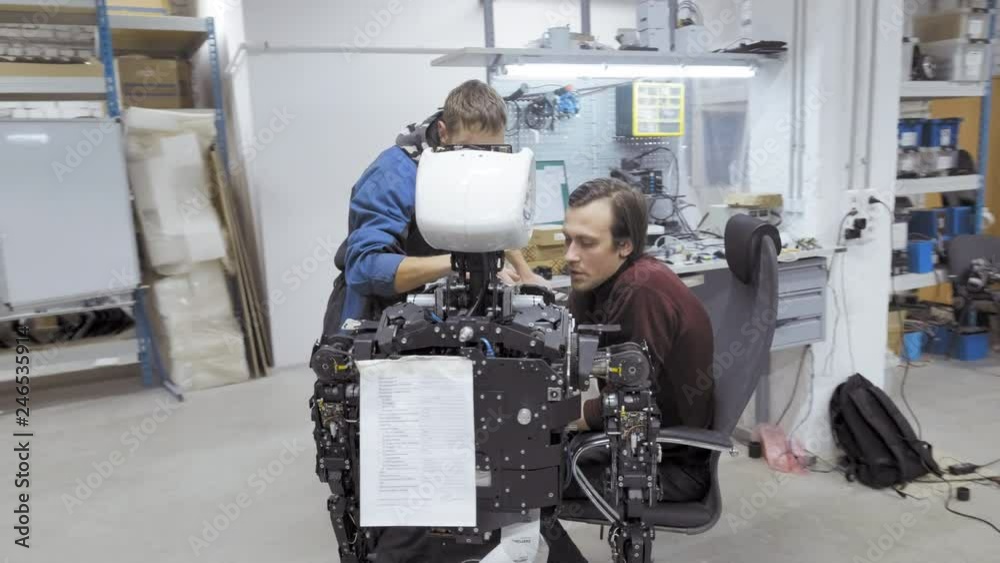 Factory for the production of robots. Two engineers are examining a ...