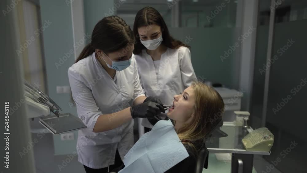 Vidéo Stock Female dentist and nurse in white gowns starting examining ...