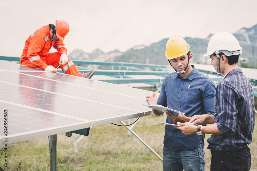 engineer in solar power plant working on installing solar panel ...