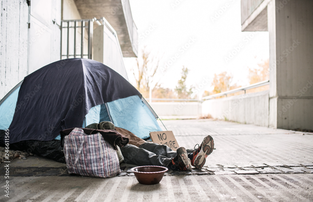Foto de Legs and feet of homeless beggar man lying on the ground in ...