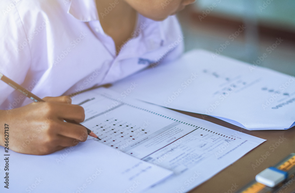 Student hand holding pencil writing doing examination with blurred ...