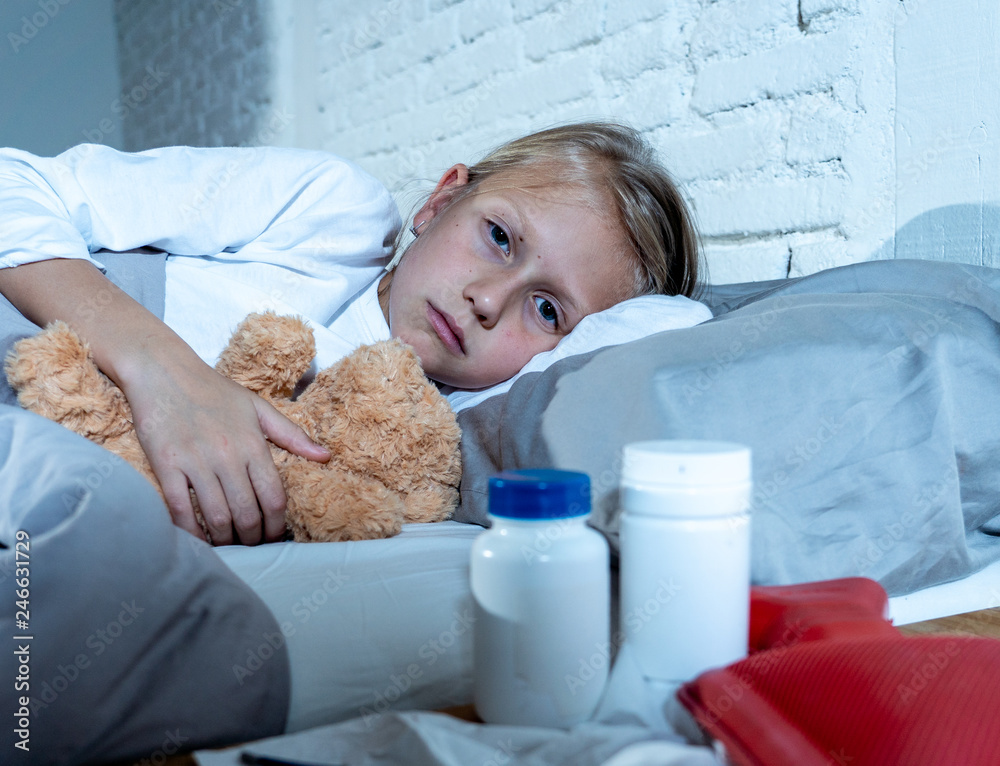 Little girl lying sick in bed feeling sick in pain with high fever ...