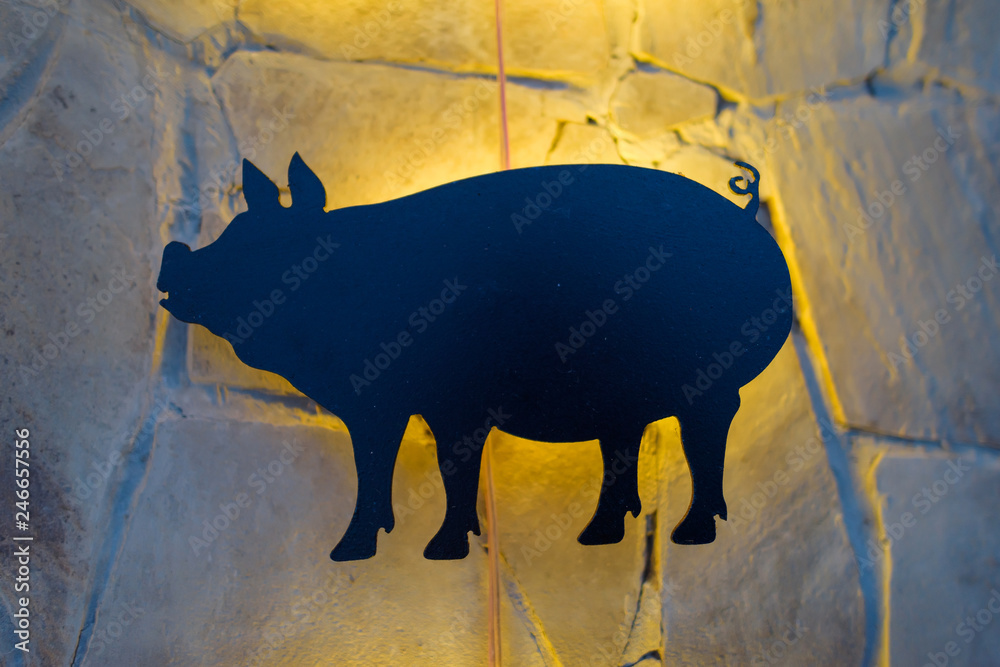 Plastic figure of a pig. Wall decor under the stone. Decorating the ...