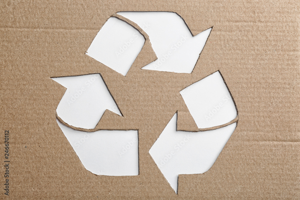 Sheet of cardboard with cutout recycling symbol on white background ...