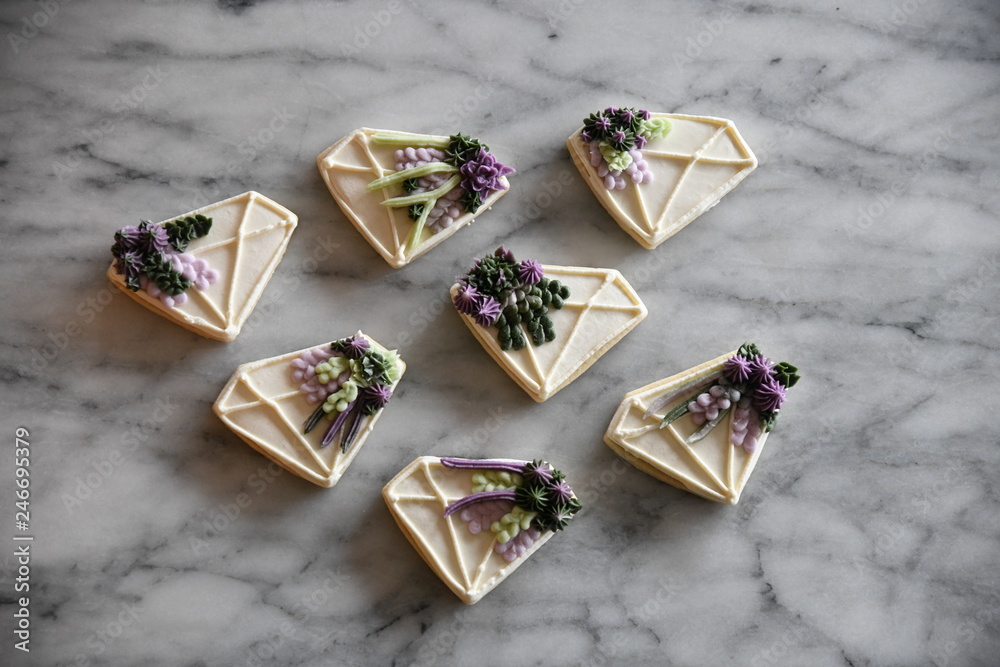 Diamond shaped cookies with white, purple, and green frosting Stock ...