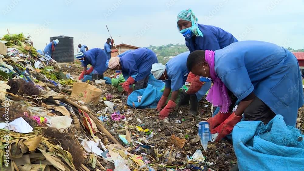Women manually separating different types of household waste into a ...
