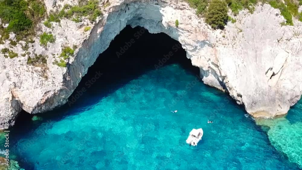 Aerial bird's eye view video taken by drone of caves and boats docked ...