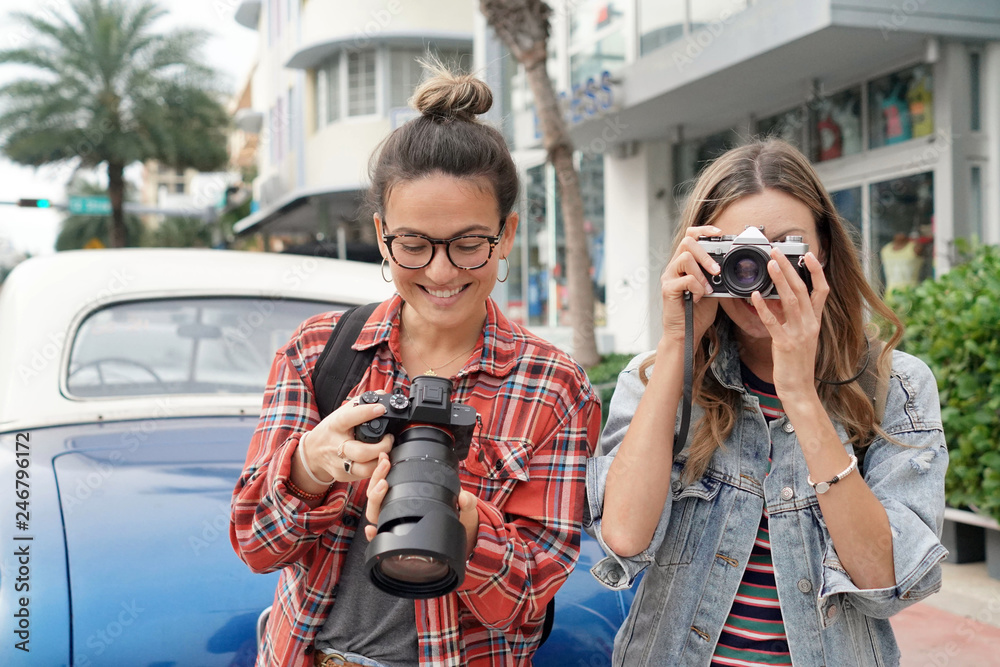 Young smiling photography students taking photos outdoors in urban ...