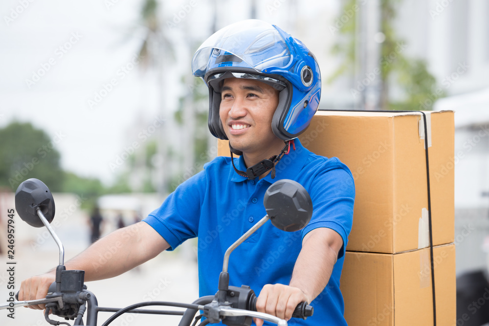 Delivery boy on motorcycle with trunk parcel box driving to fast in ...