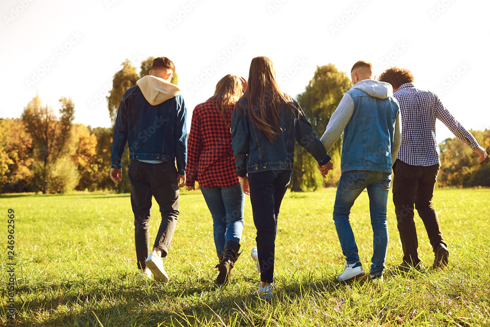 Young people walk in the park in spring. Stock Photo | Adobe Stock