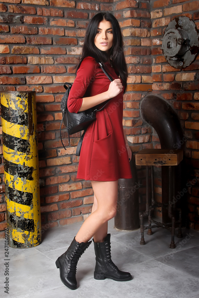 Fashion photo of young beautiful female model in ankle boots and dress ...
