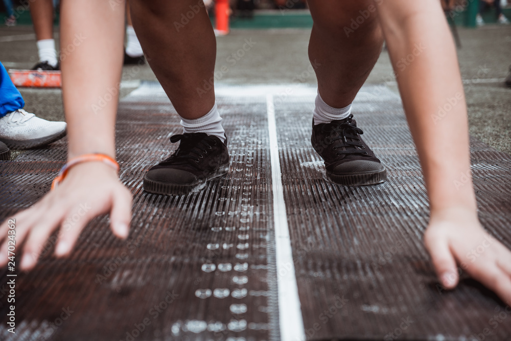 Students boy taking long jump on rubber board pid or sand pid during a ...