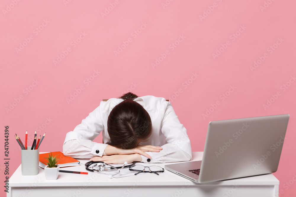 Female doctor laid her head down on desk, work on computer, medical ...