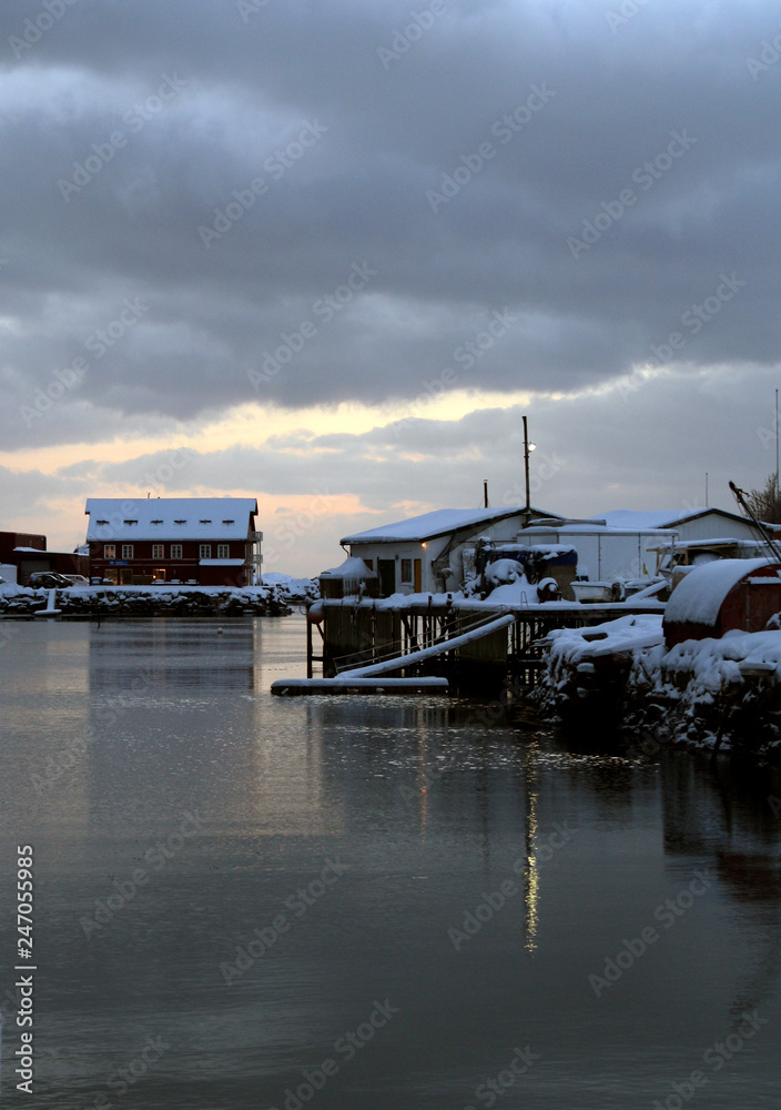 Traditional village houses covered with snow on the waterfront of the ...