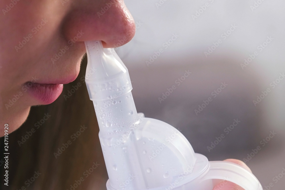 Use nebulizer and inhaler for the treatment. Young woman inhaling ...